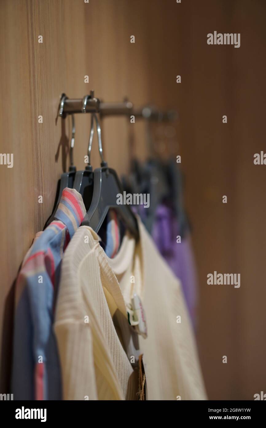 Сlothes on hangers in the fitting room Stock Photo - Alamy
