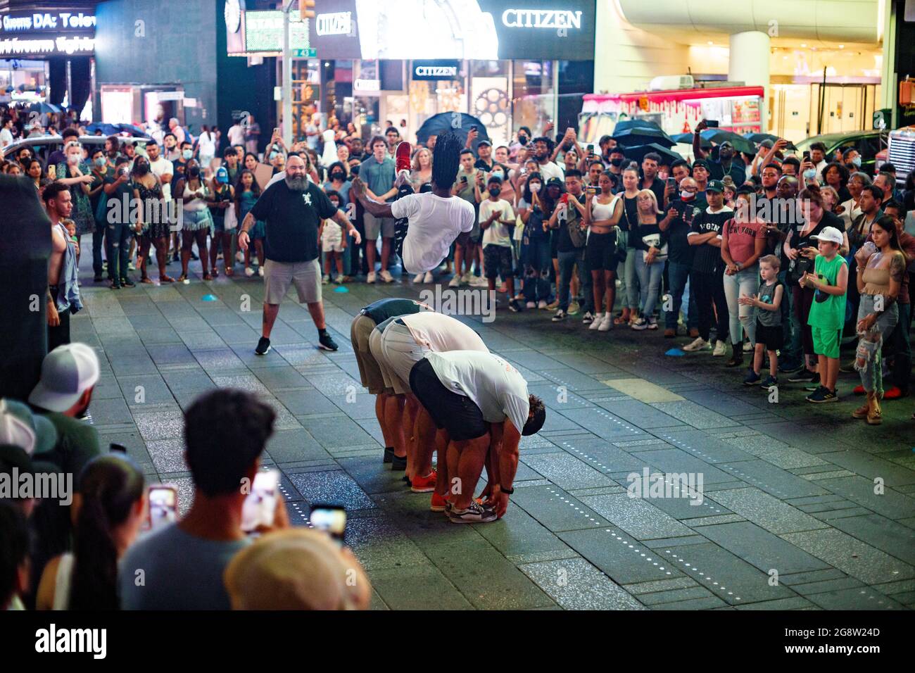Street performer jumps over members of a crowd in Time’s Square who ...