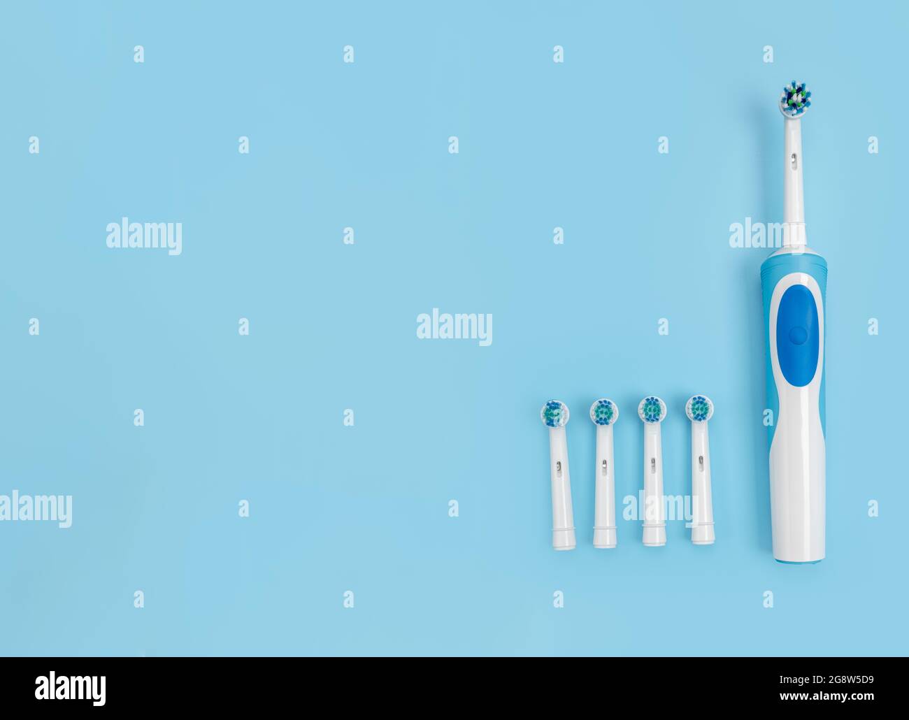 Modern electric toothbrush set with replacement heads on flat lay ...
