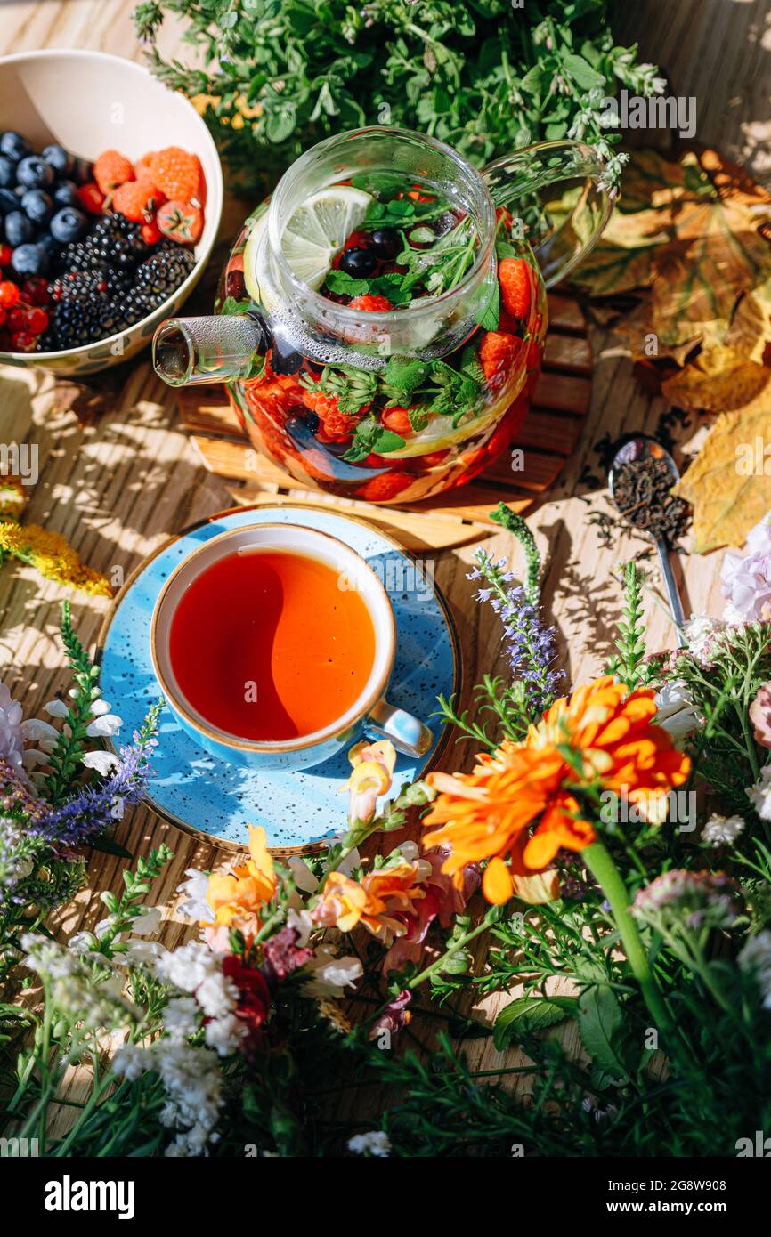 natural aromatic fruit tea in a transparent teapot and in a cup among ...
