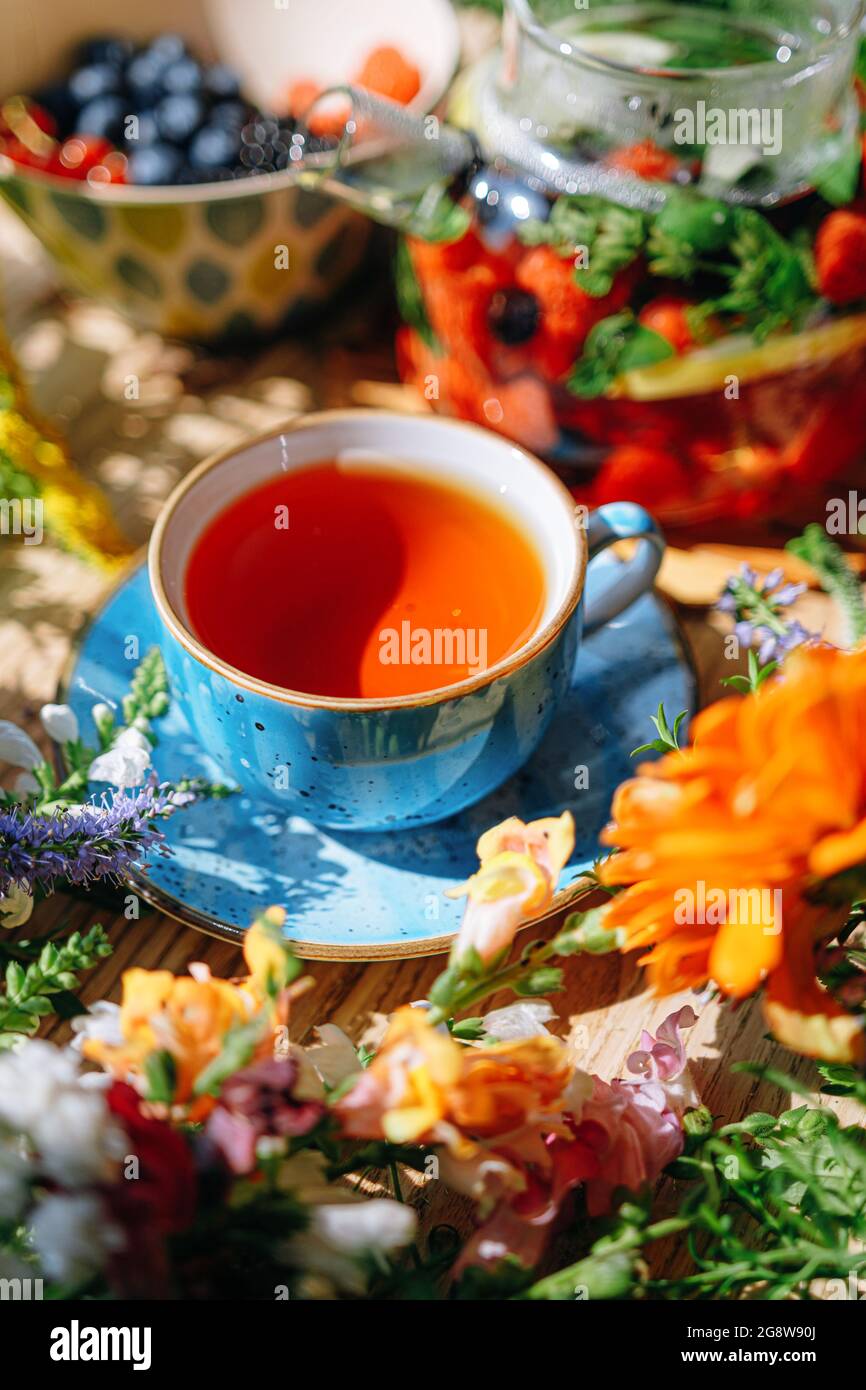 natural aromatic fruit tea in a transparent teapot and in a cup among ...