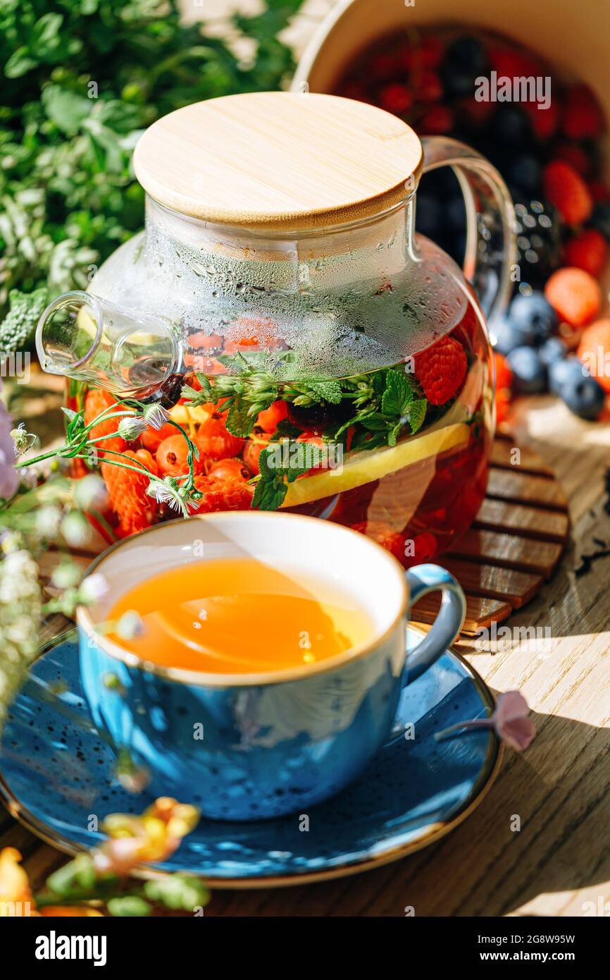 natural aromatic fruit tea in a transparent teapot and in a cup among ...