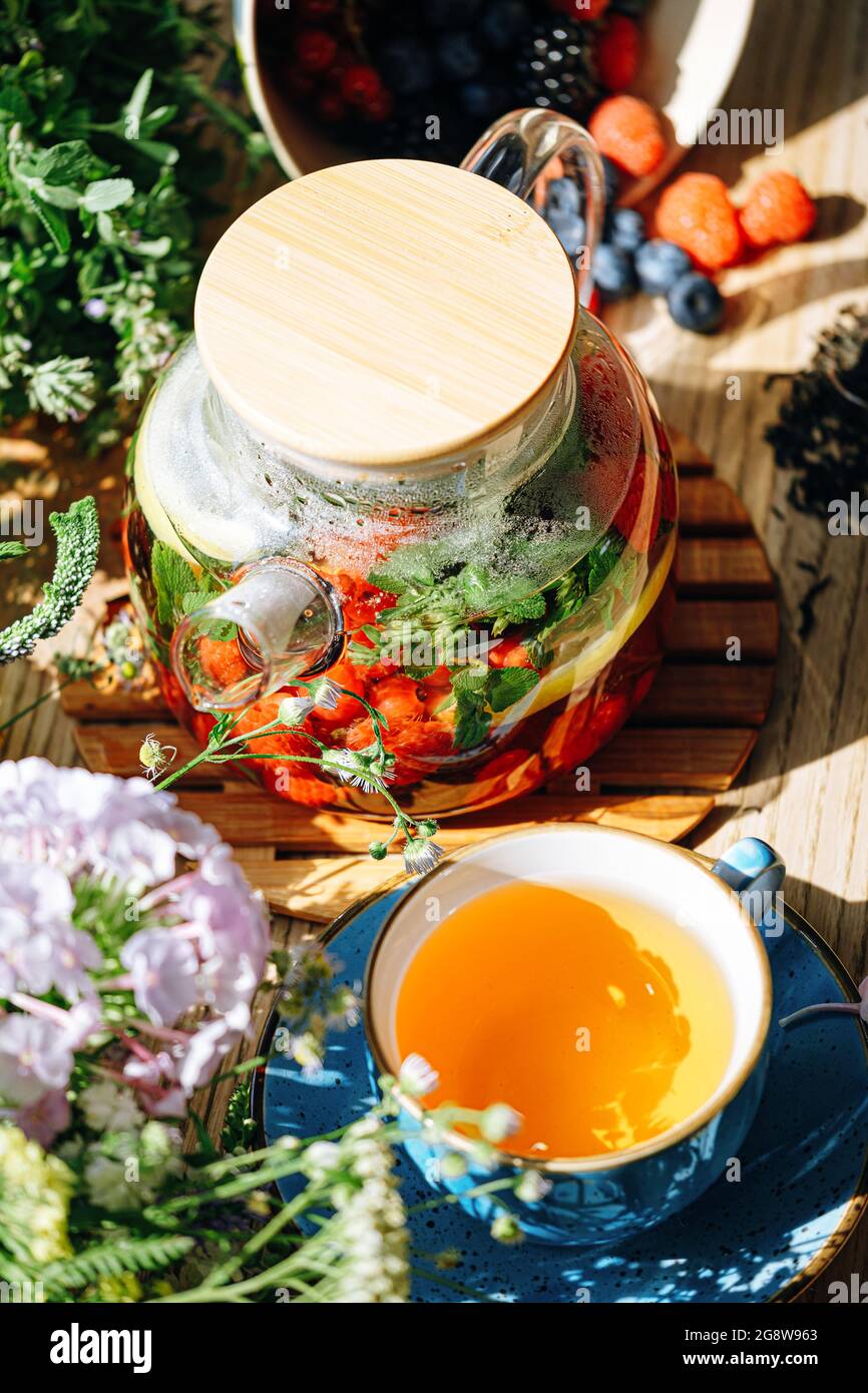 natural aromatic fruit tea in a transparent teapot and in a cup among ...