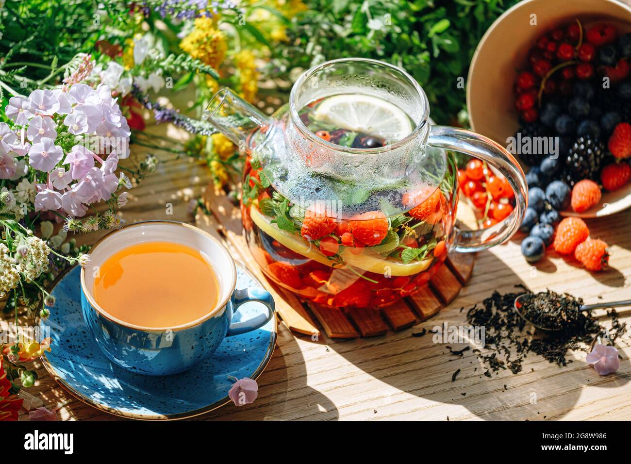 natural aromatic fruit tea in a transparent teapot and in a cup among ...