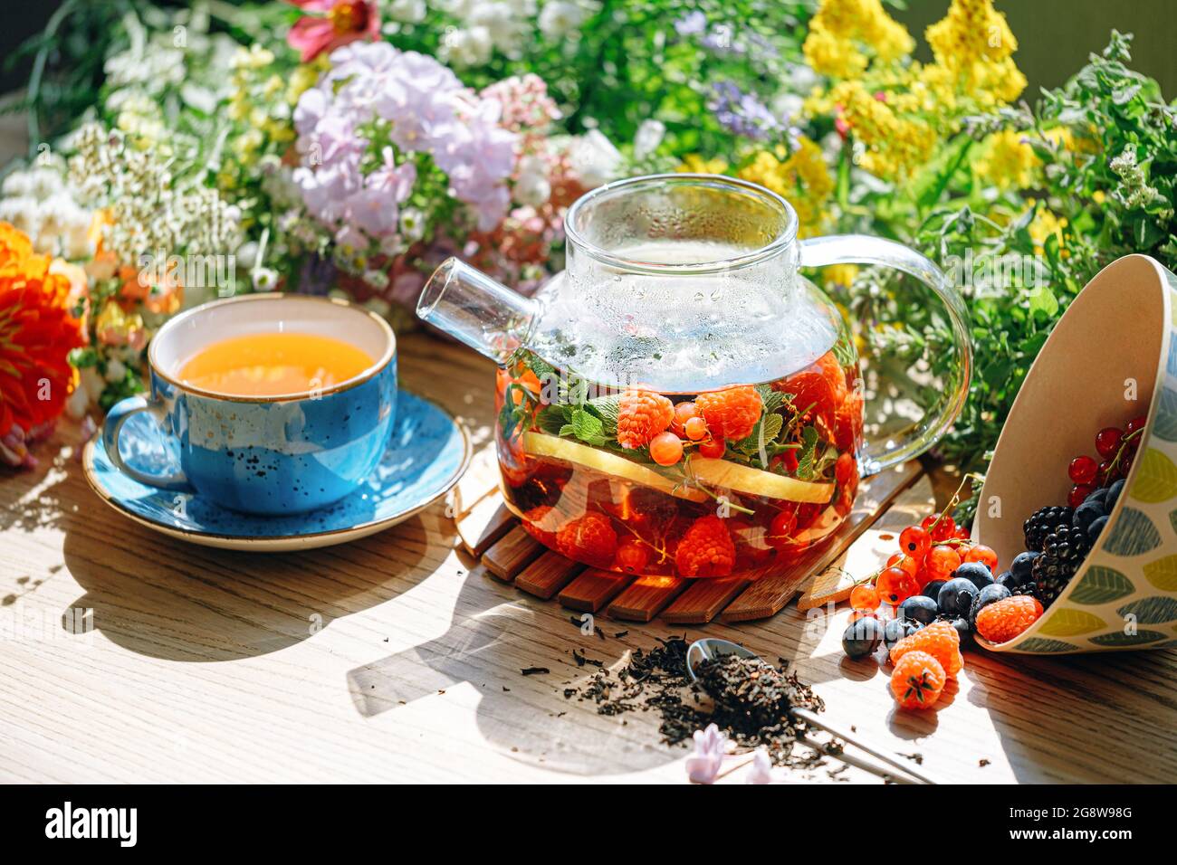 natural aromatic fruit tea in a transparent teapot and in a cup among ...