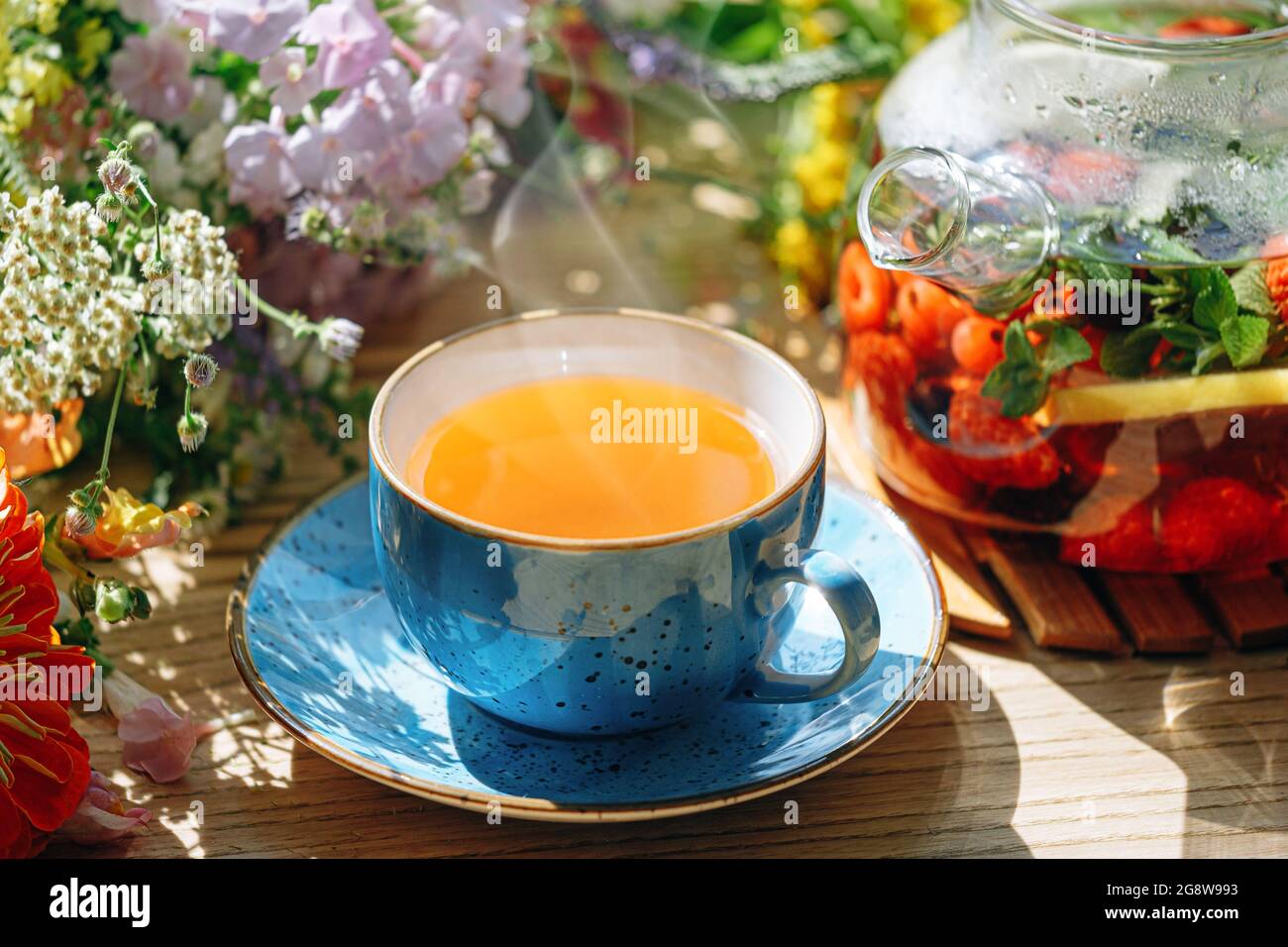 natural aromatic fruit tea in a transparent teapot and in a cup among ...