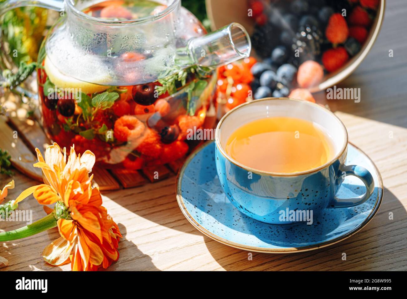natural aromatic fruit tea in a transparent teapot and in a cup among ...