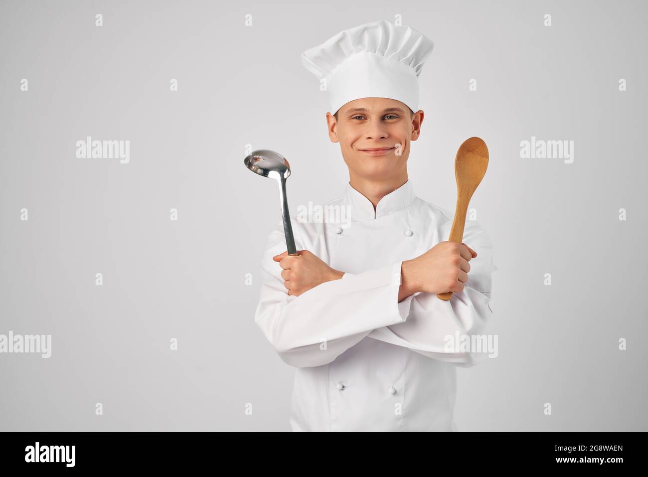 cook with a ladle and a wooden spoon in hands kitchen work Stock Photo ...