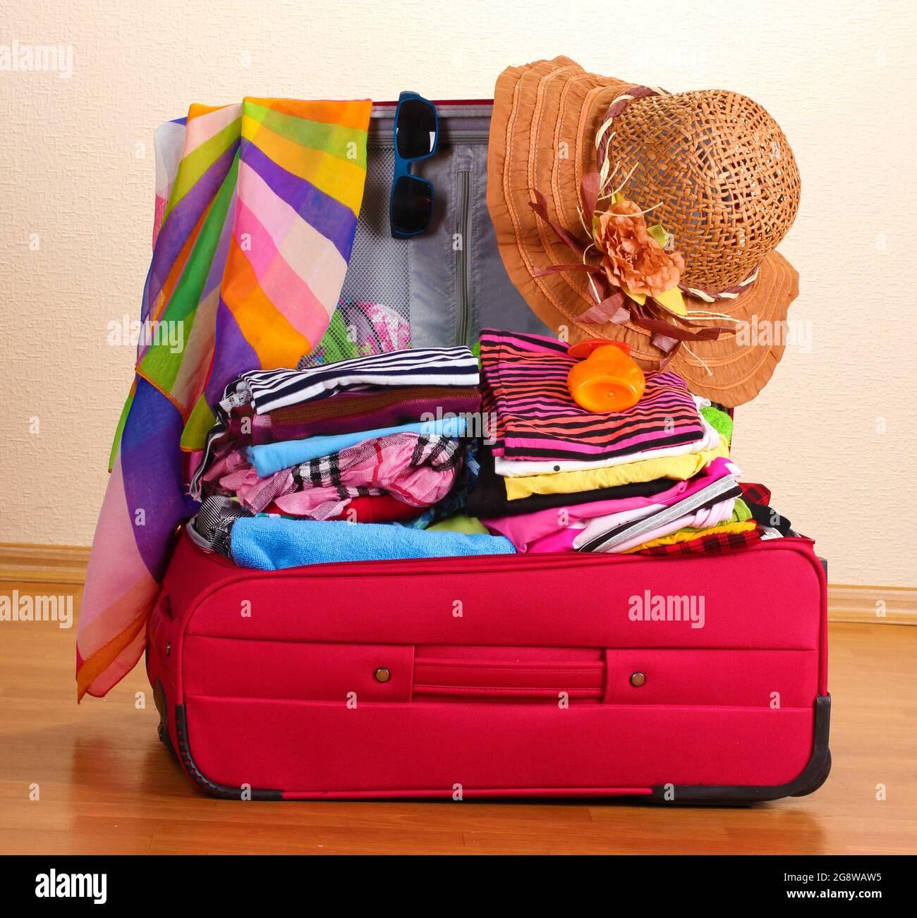 Open red suitcase with clothing in the room Stock Photo - Alamy