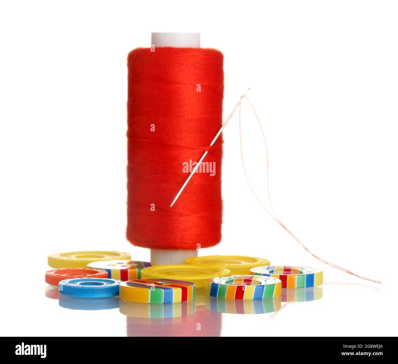 Red bobbin with needle and buttons isolated on white Stock Photo - Alamy