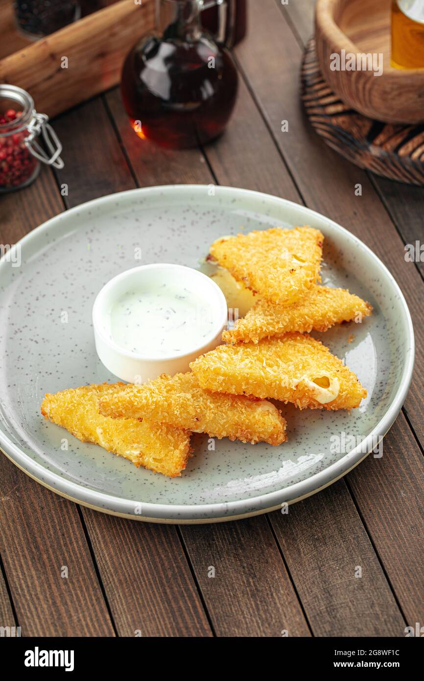 Deep fried cheese triangles with sour cream sauce Stock Photo - Alamy