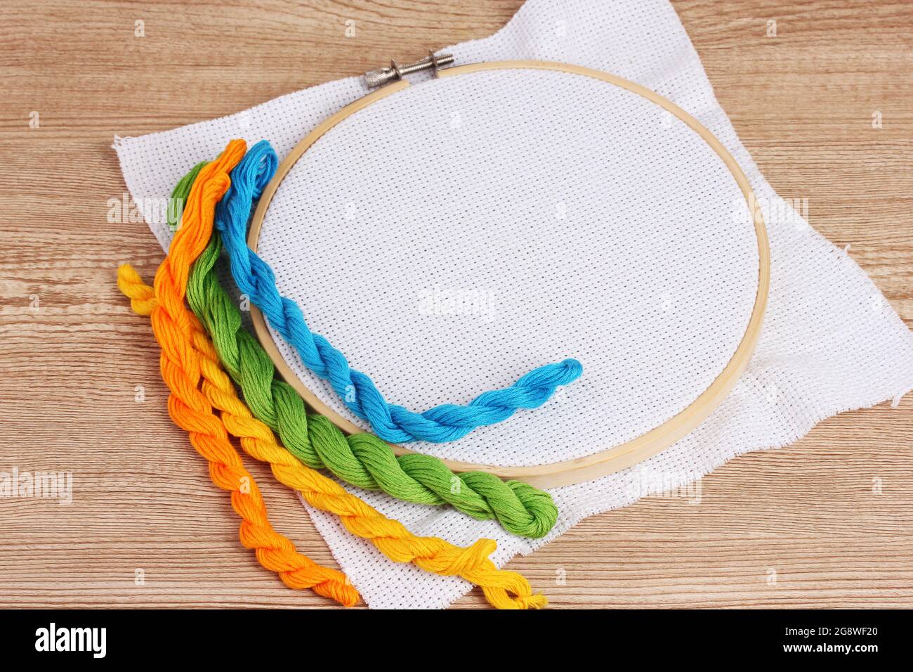 The embroidery hoop with canvas and bright sewing threads for ...