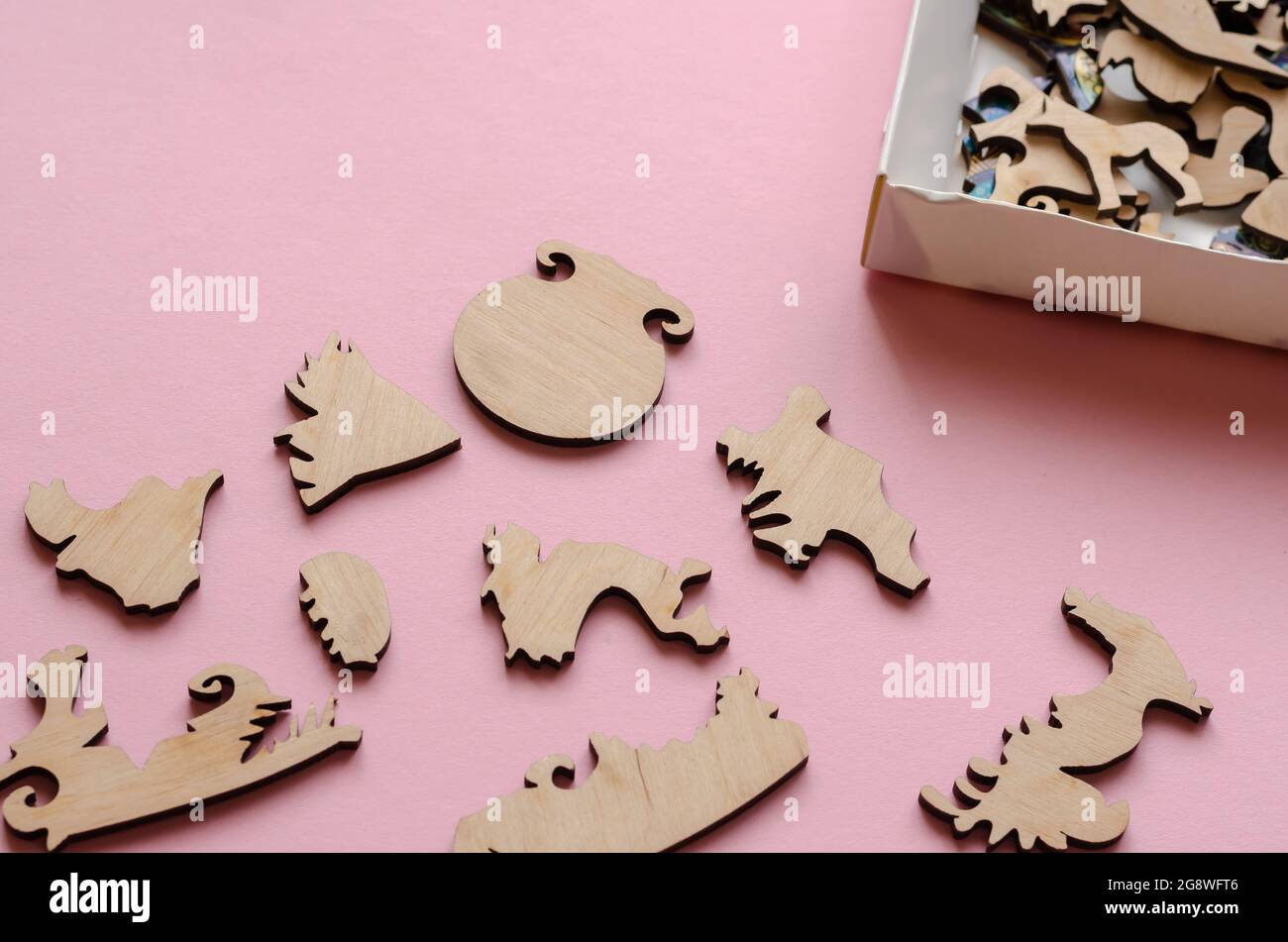 Wooden puzzle on a pink background. A complex puzzle of highly accurate ...