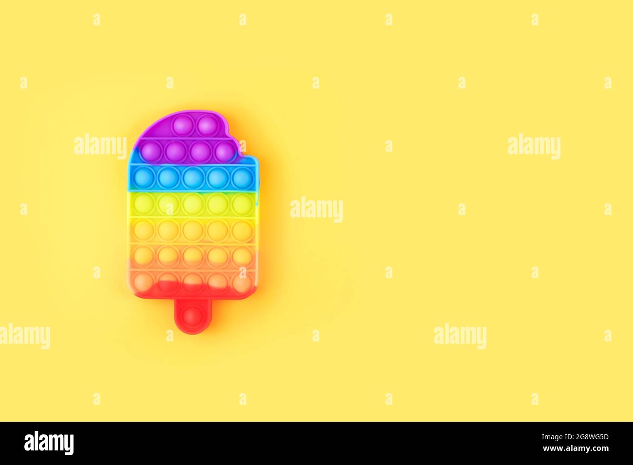 Push pop fidget toy isolated on yellow background Stock Photo - Alamy