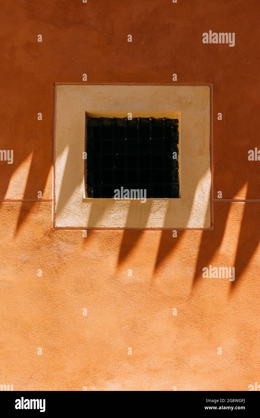 Vertical shot of a small blacked-out window on a beautiful orange ...