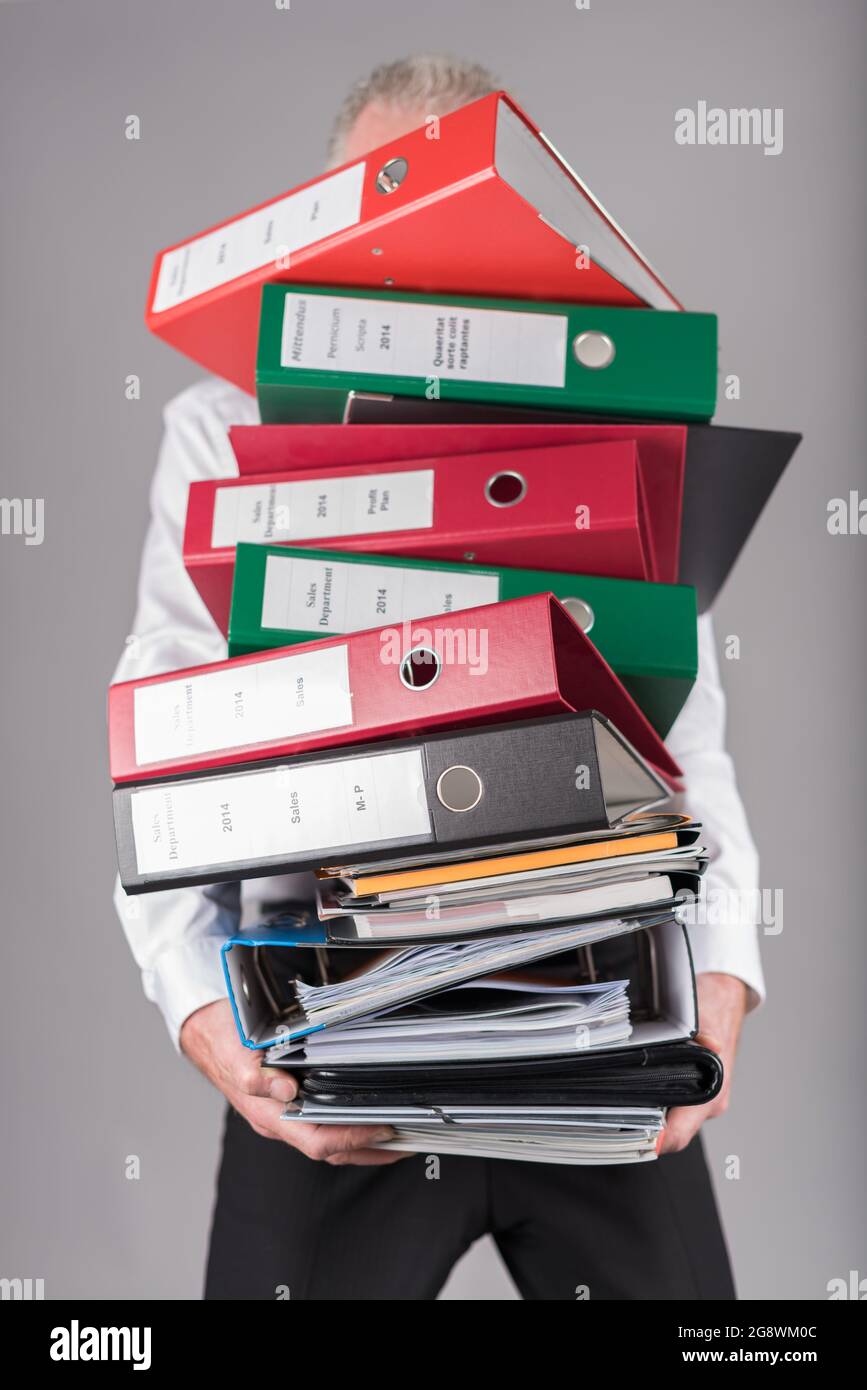 Businessman overloaded carrying a pile of binders and folders Stock ...