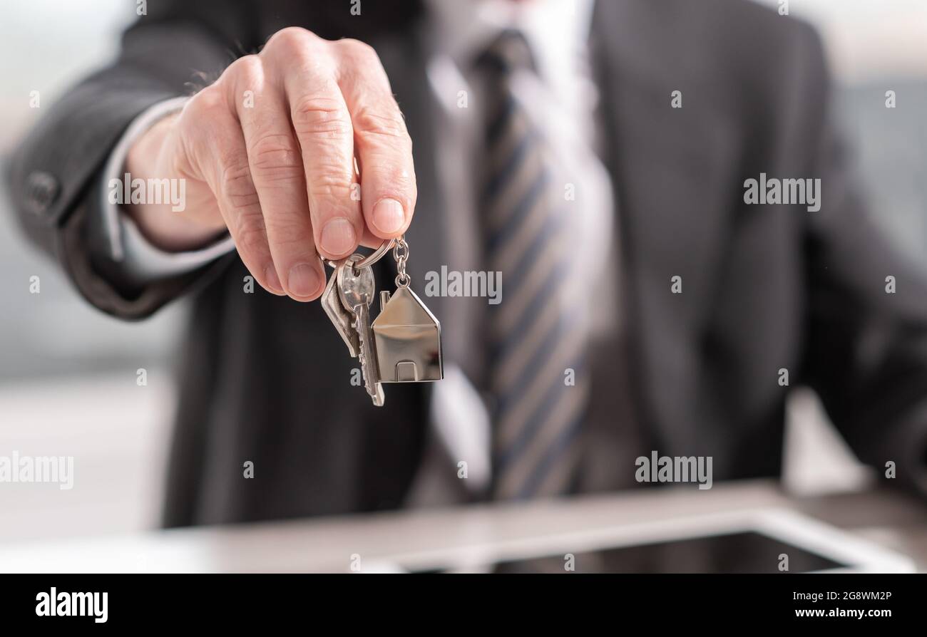 Real estate agent offering house keys Stock Photo - Alamy