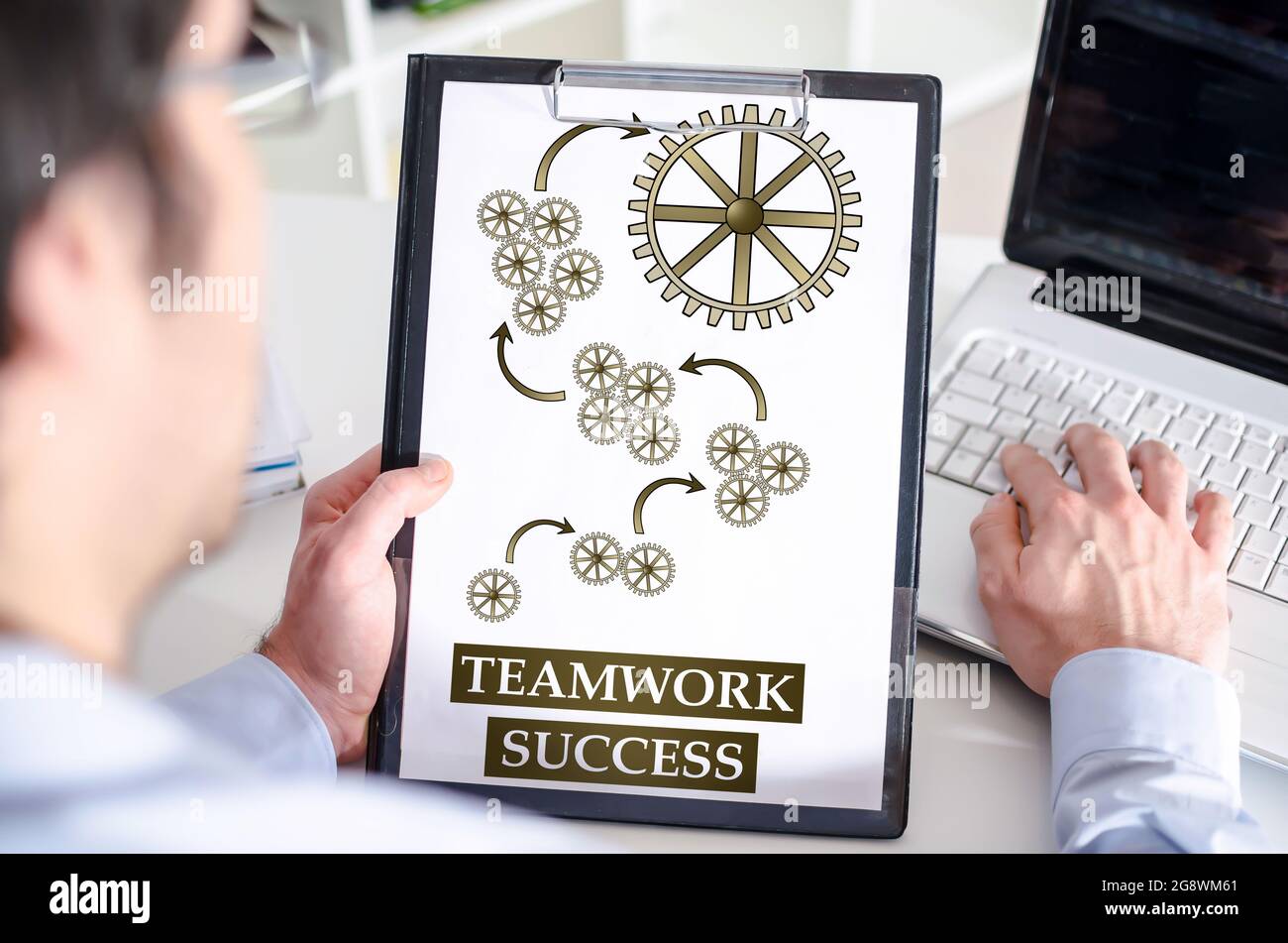 Man holding a clipboard with teamwork success concept Stock Photo - Alamy