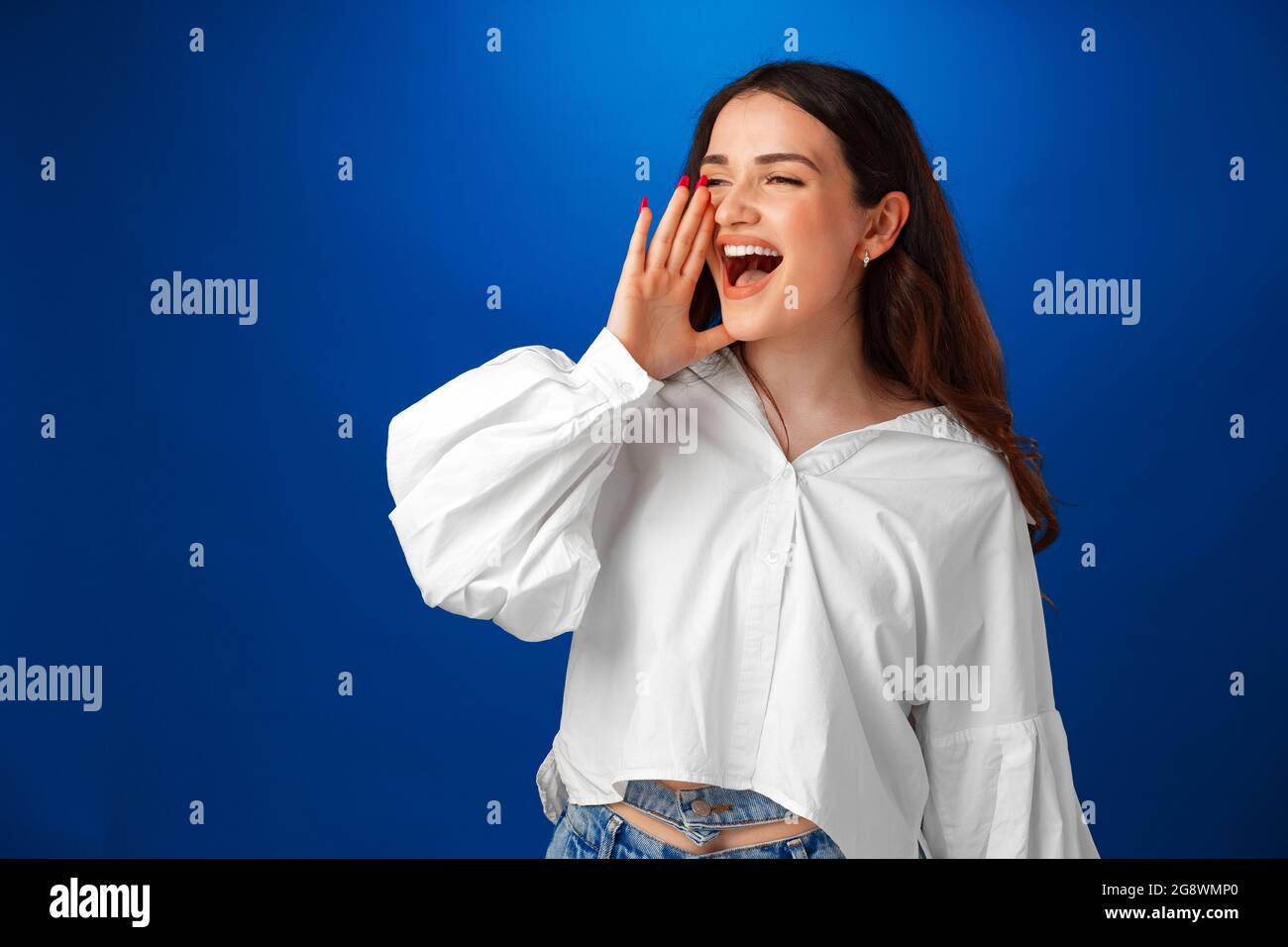 Crying emotional young woman screaming on blue studio background Stock ...