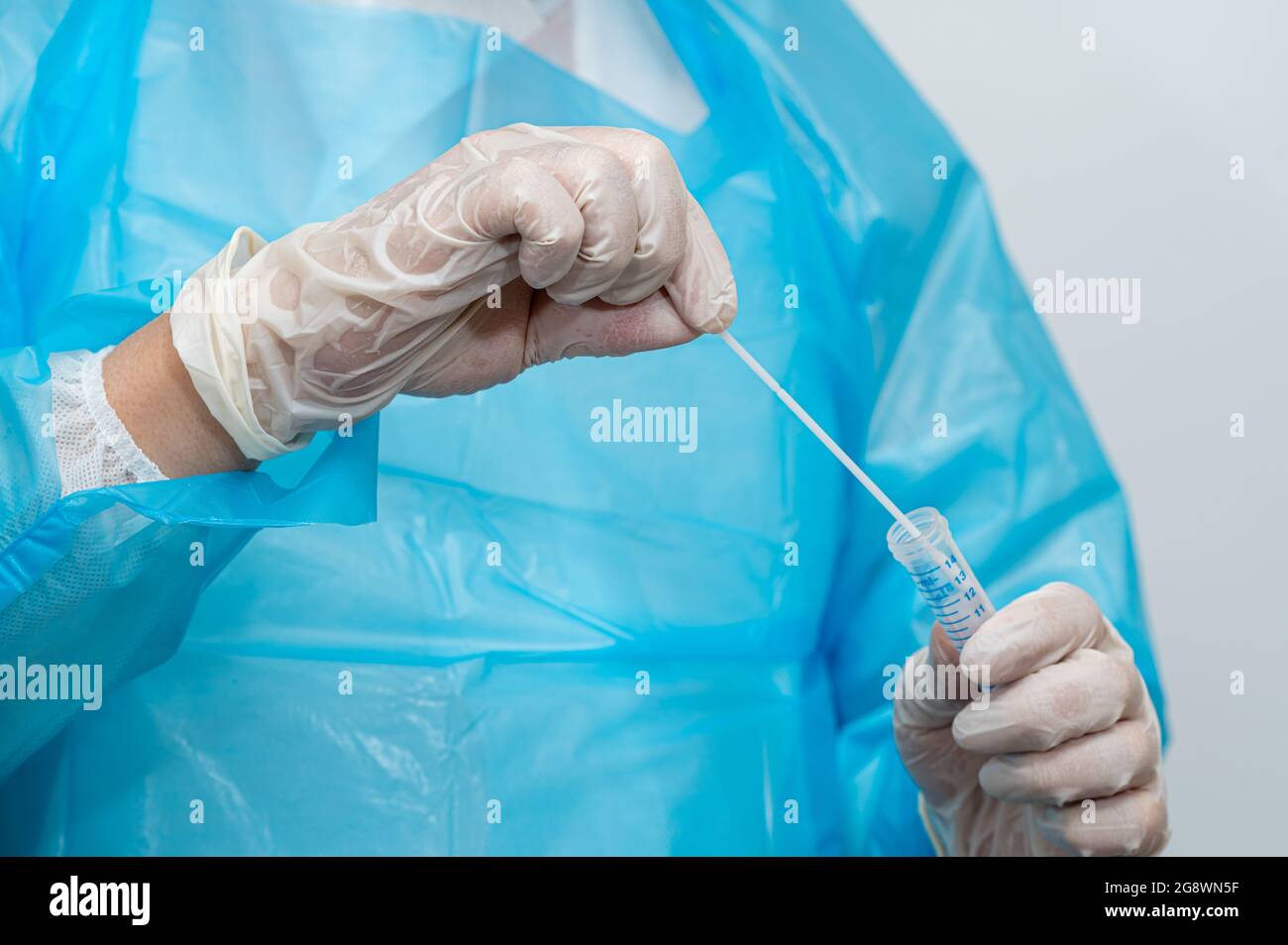 A medical worker holding a swab sample collection kit Stock Photo - Alamy