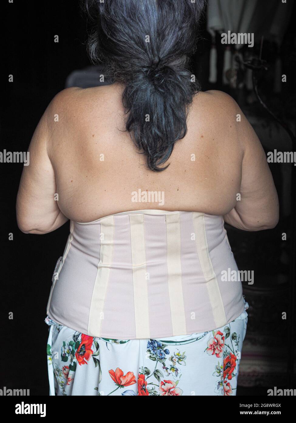 Rear view of a senior woman wearing a semi-rigid thoracic lumbosacral ...