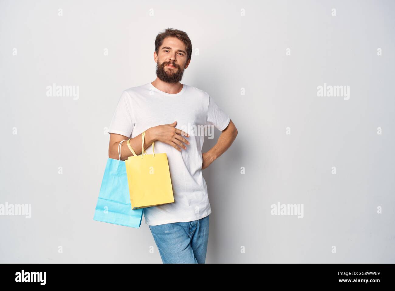 Cheerful man in white t-shirt with packs of shopping emotions lifestyle ...