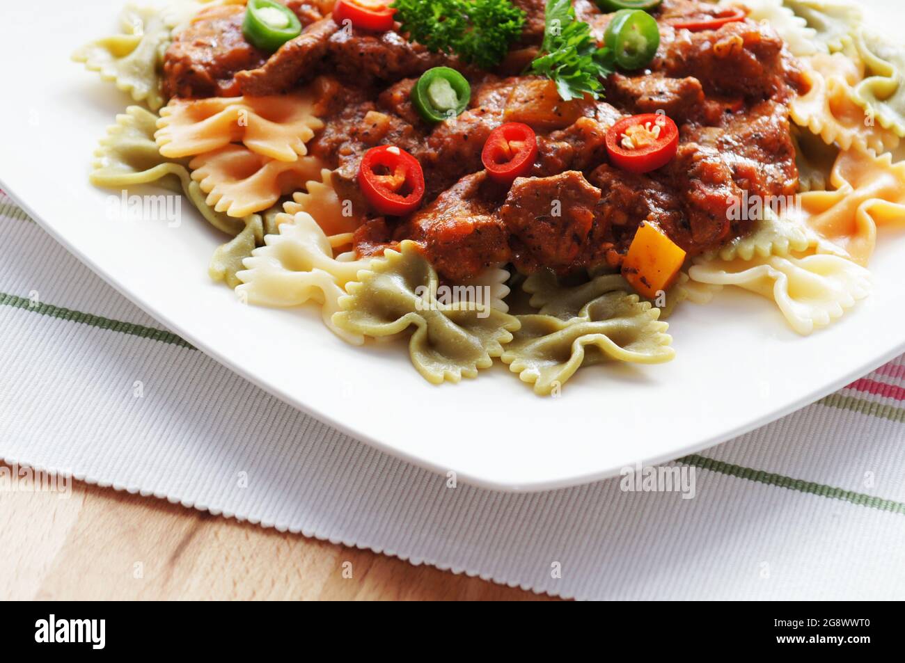 Close up of Stew with pasta with meat and chill on a white plate Stock ...