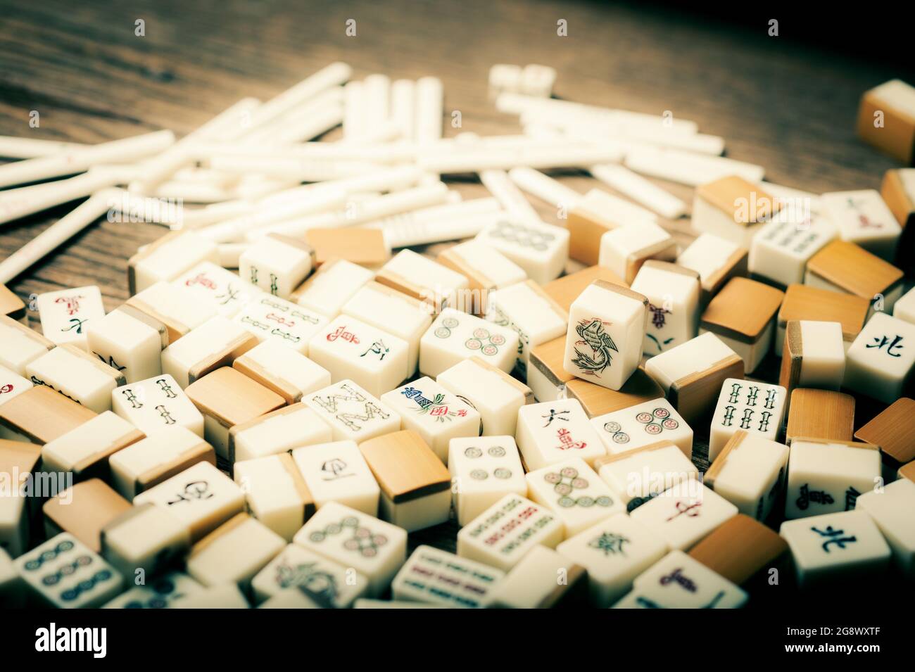Many old mahjong tiles on wooden table. Mahjong is the ancient asian ...