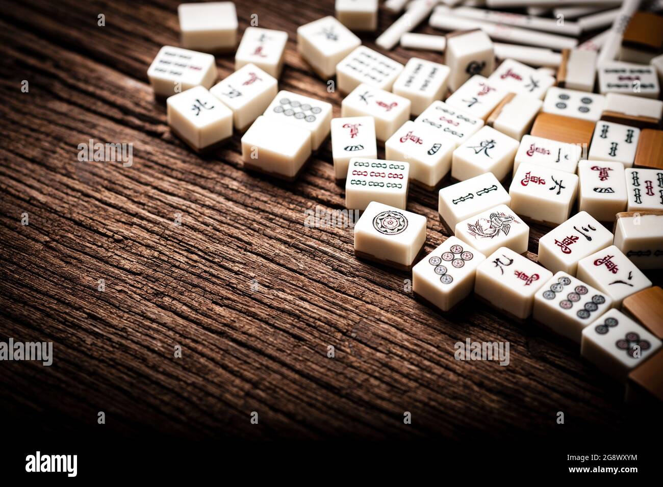 Many old mahjong tiles on wooden table. Mahjong is the ancient asian ...