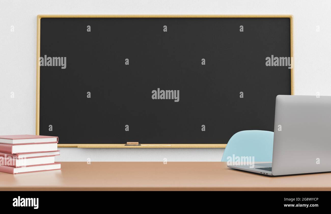 teacher's table with laptop and pile of books and empty chalkboard ...