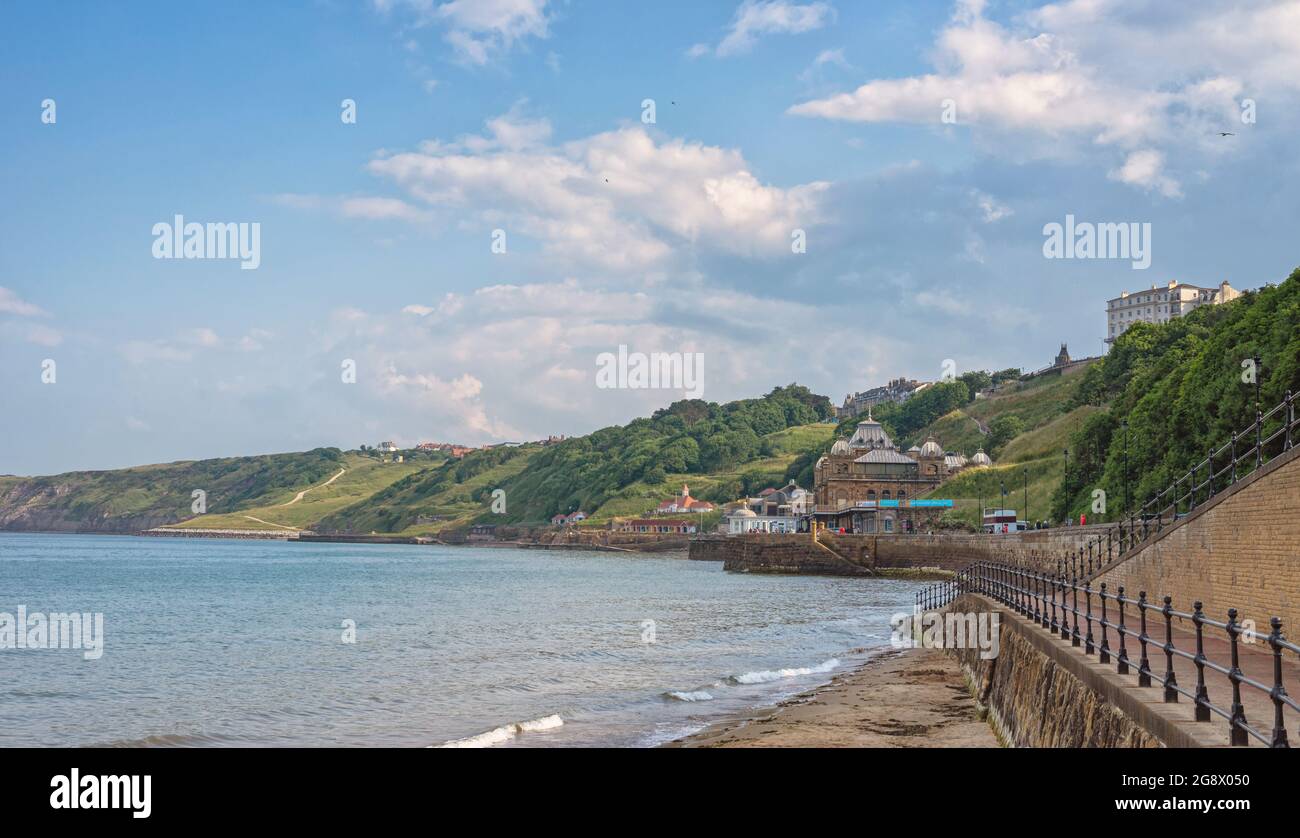 A seaside scene with a hill and a white building on the skyline. A path ...