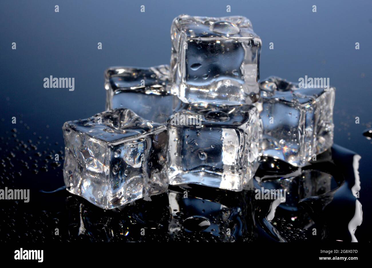 Melting ice cubes on blue background Stock Photo - Alamy