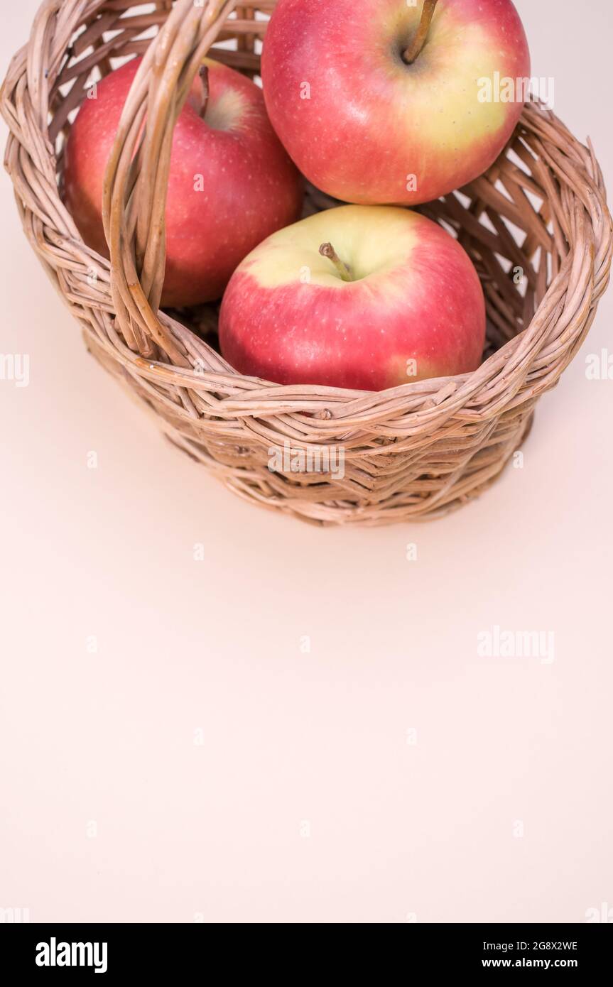 Basket of red apples isolated on a light background with free space for ...