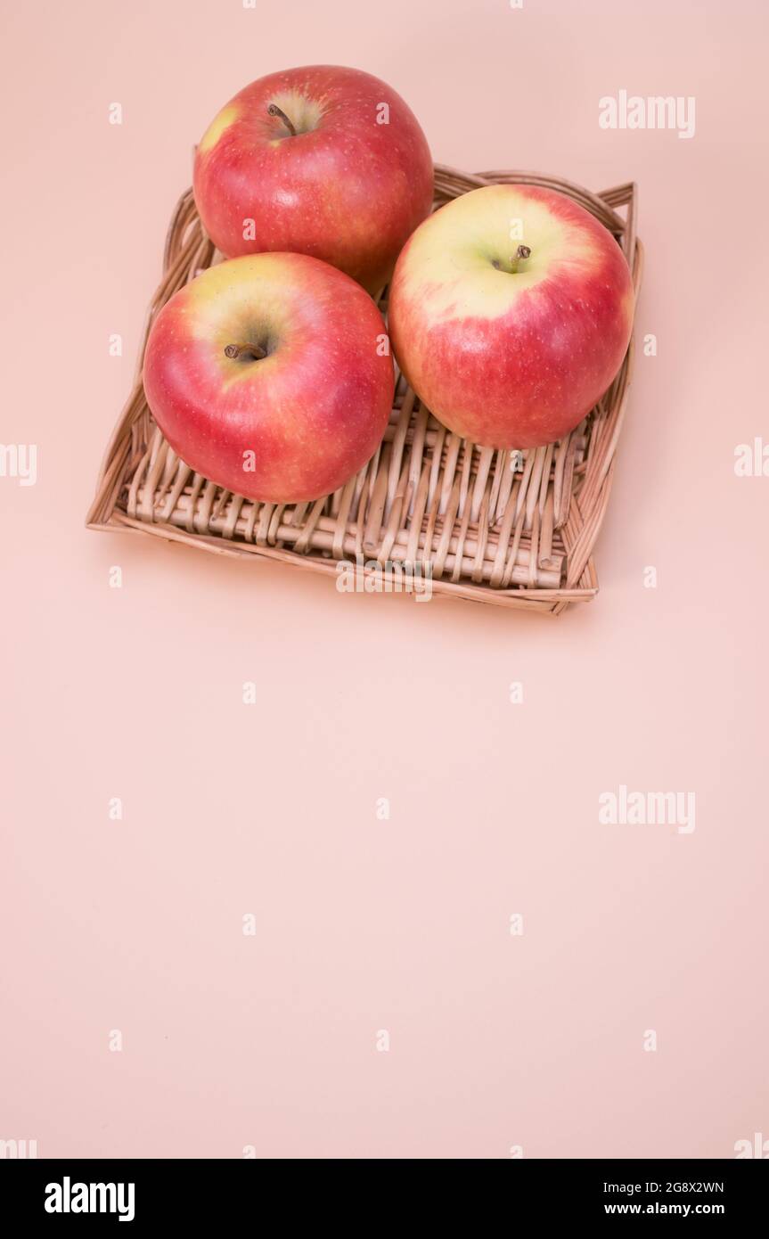 Tray of red apples isolated on a pink background with free space for ...