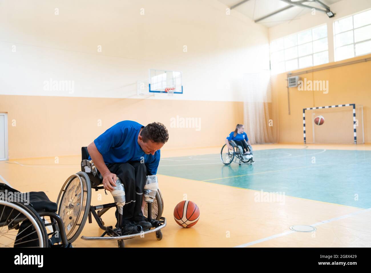 a handicapped basketball player prepares for a match while sitting in a ...