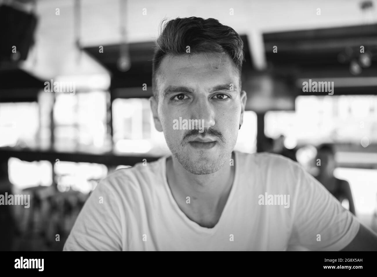 Grayscale shot of a handsome Bosnian man with a stylish haircut ...