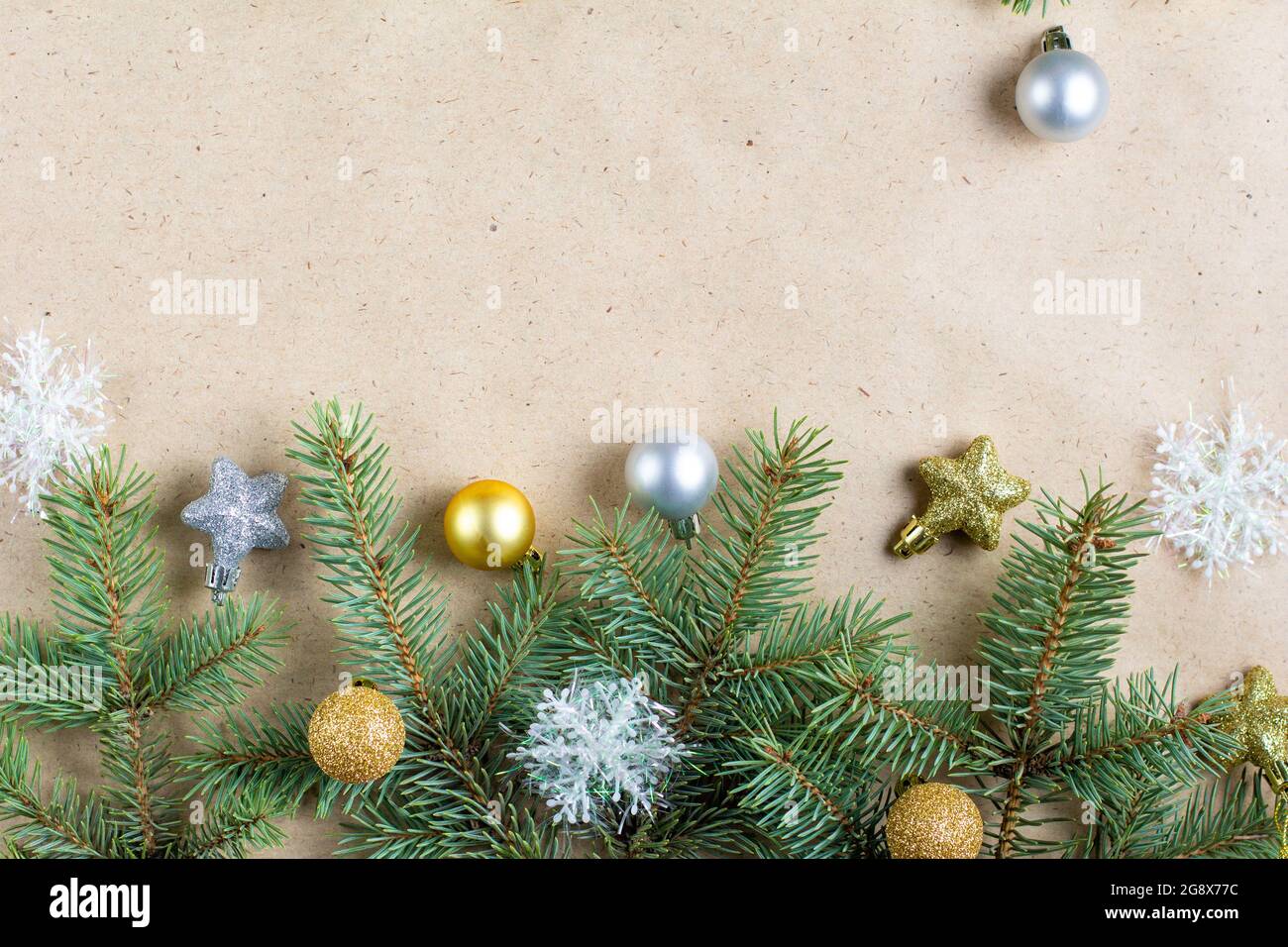 border of fir tree branch with gold decoration on craft paper for ...