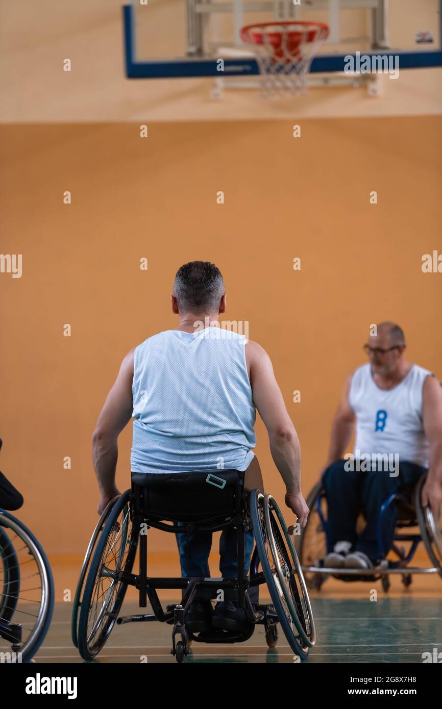 a war invalid in a wheelchair trains with a ball at a basketball club ...