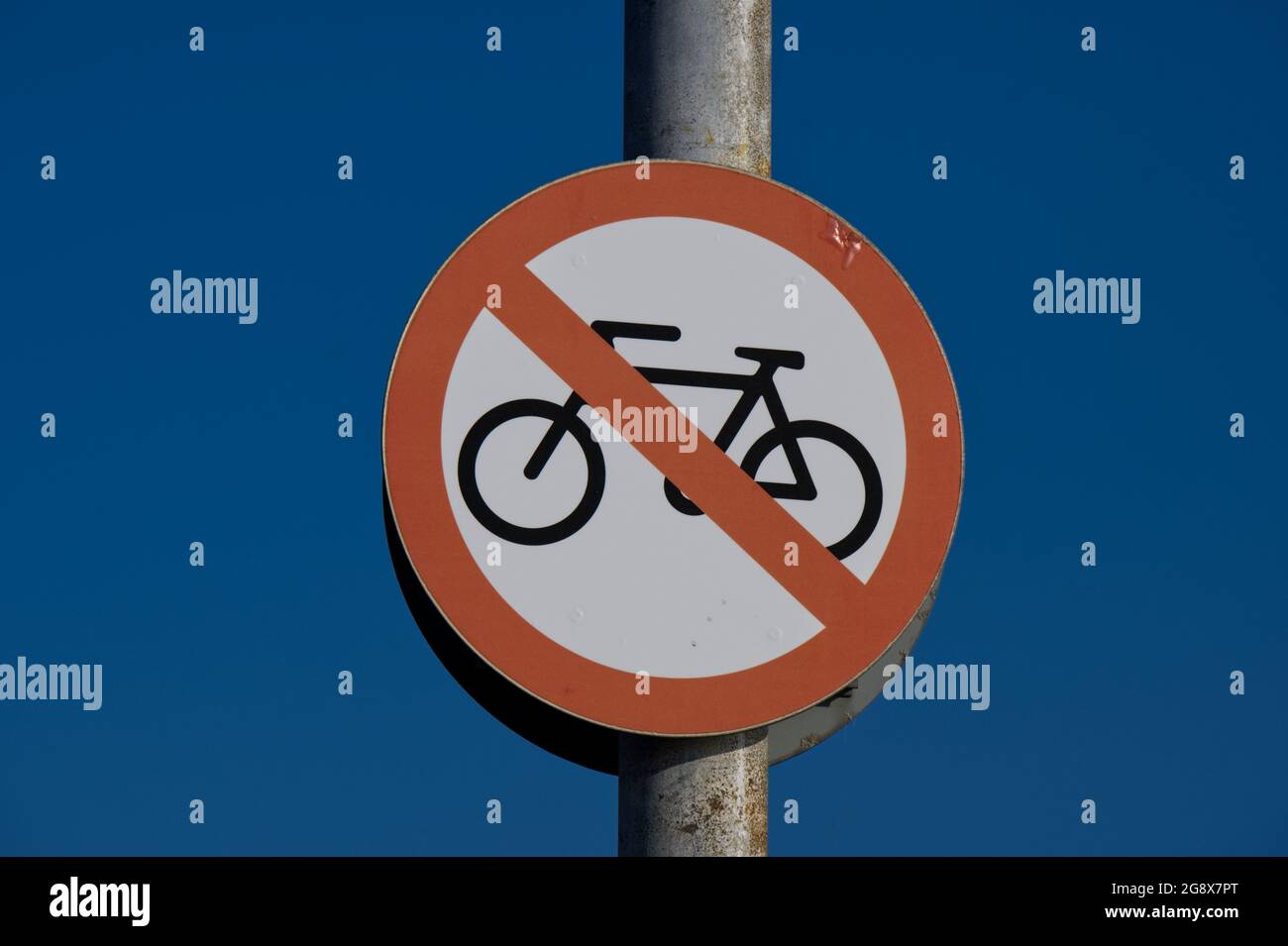 Circular no cycling road sign with diagonal line through UK Stock Photo ...