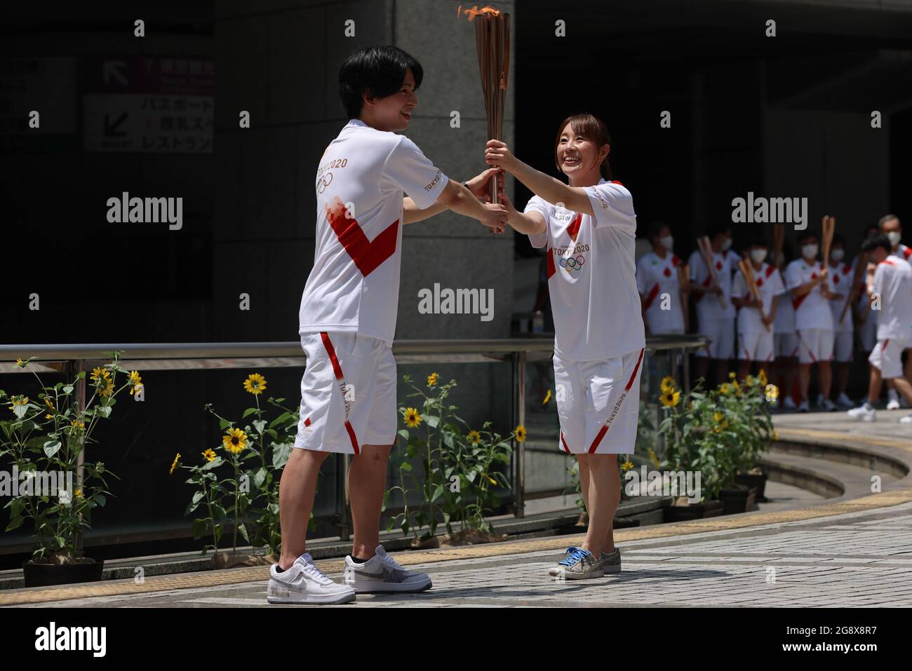 Tokyo, Japan. 23rd July, 2021. Torchbearers pose for a photo with the ...
