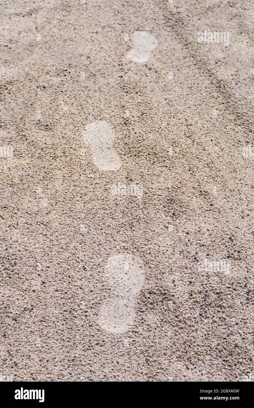 Multiple footprints on wet sand after rain. Footprints in the wet sand ...
