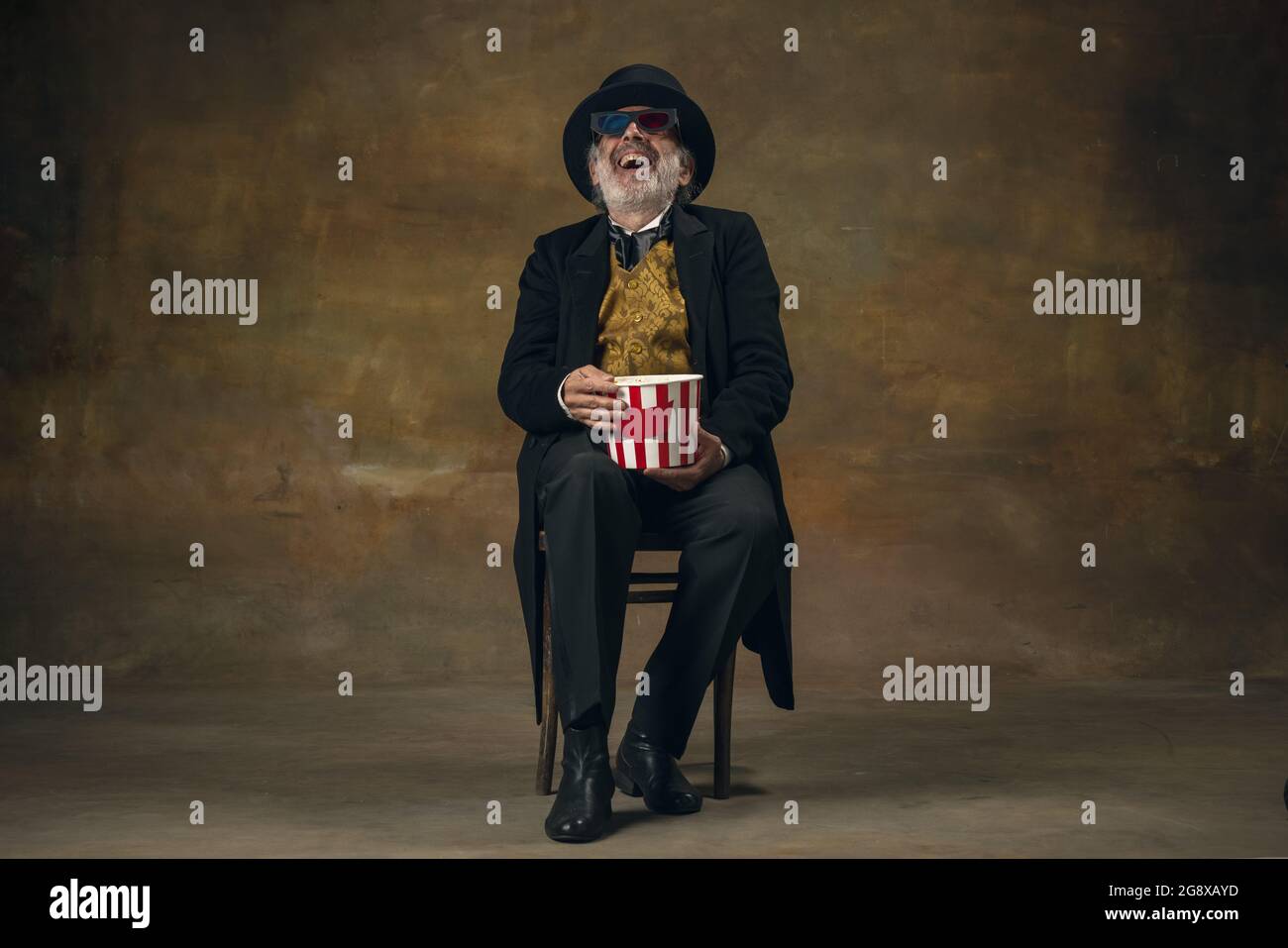 Cute senior smiling man, gentleman, aristocrat or actor watching movie ...