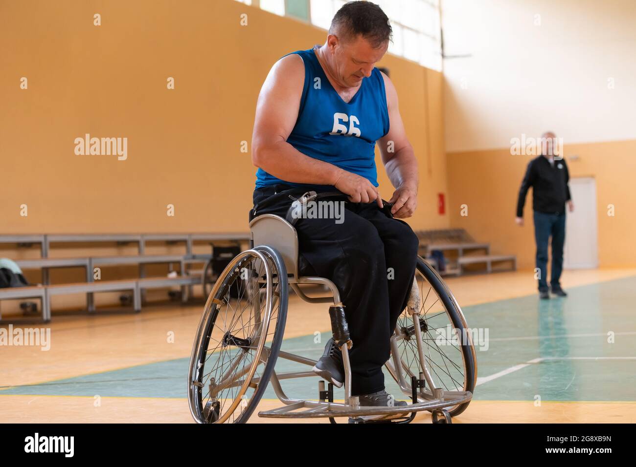 a handicapped basketball player prepares for a match while sitting in a ...