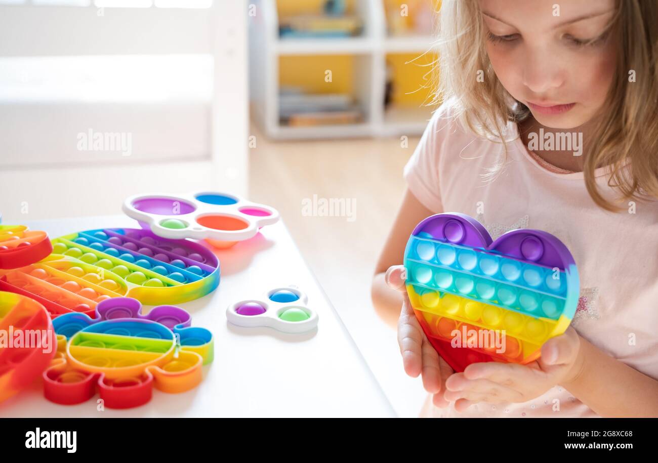 Little girl,kid,child plays with colorful pop it children's room ...