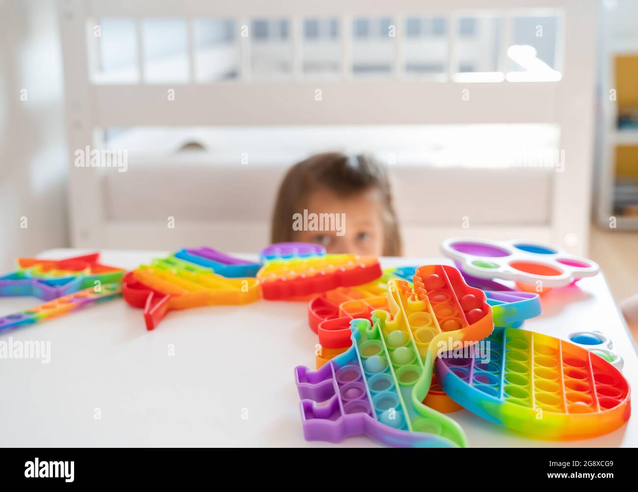 Little girl,kid,child plays with colorful pop it children's room ...