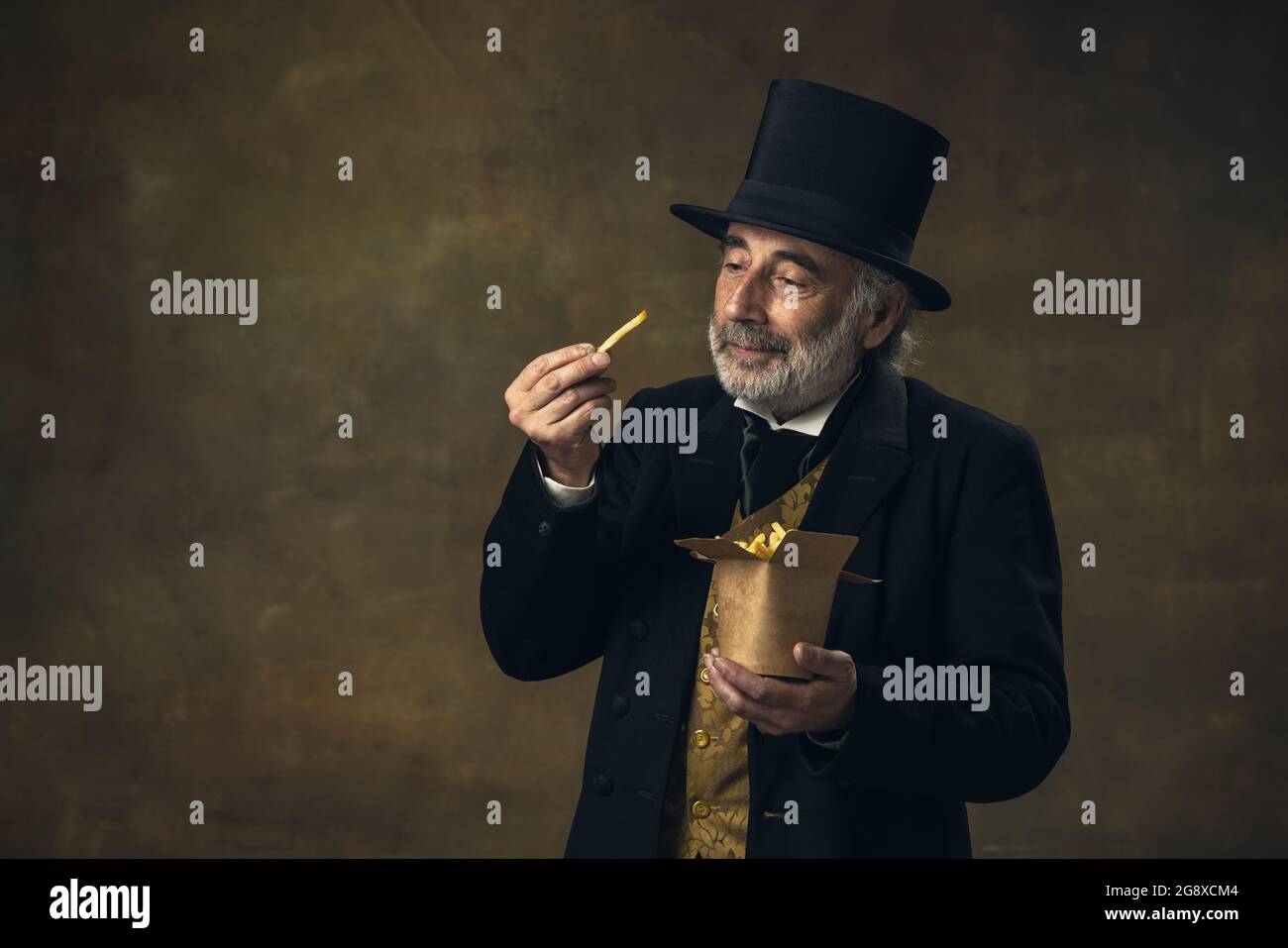 Handsome elderly gray-haired man, gentleman, aristocrat or actor eating ...