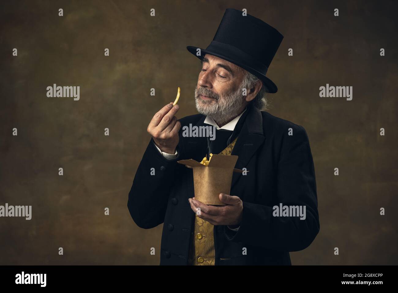 Handsome elderly gray-haired man, gentleman, aristocrat or actor eating ...