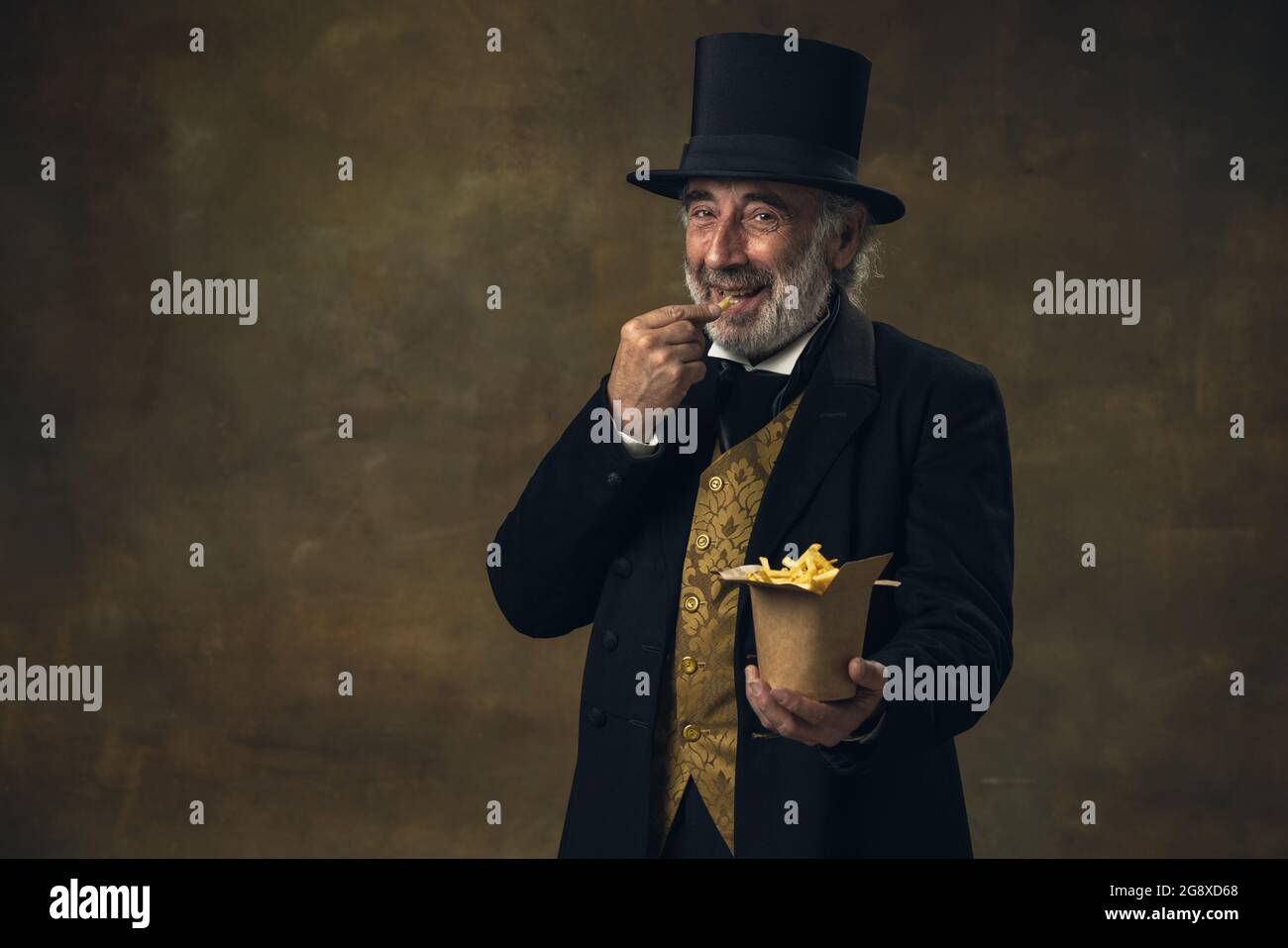 Handsome elderly gray-haired man, gentleman, aristocrat or actor eating ...