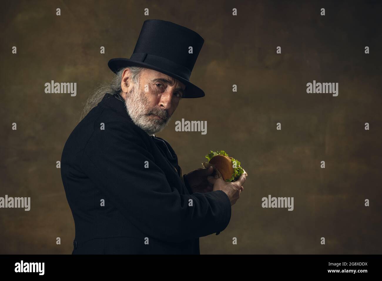 Handsome elderly gray-haired man, gentleman, aristocrat or actor eating ...