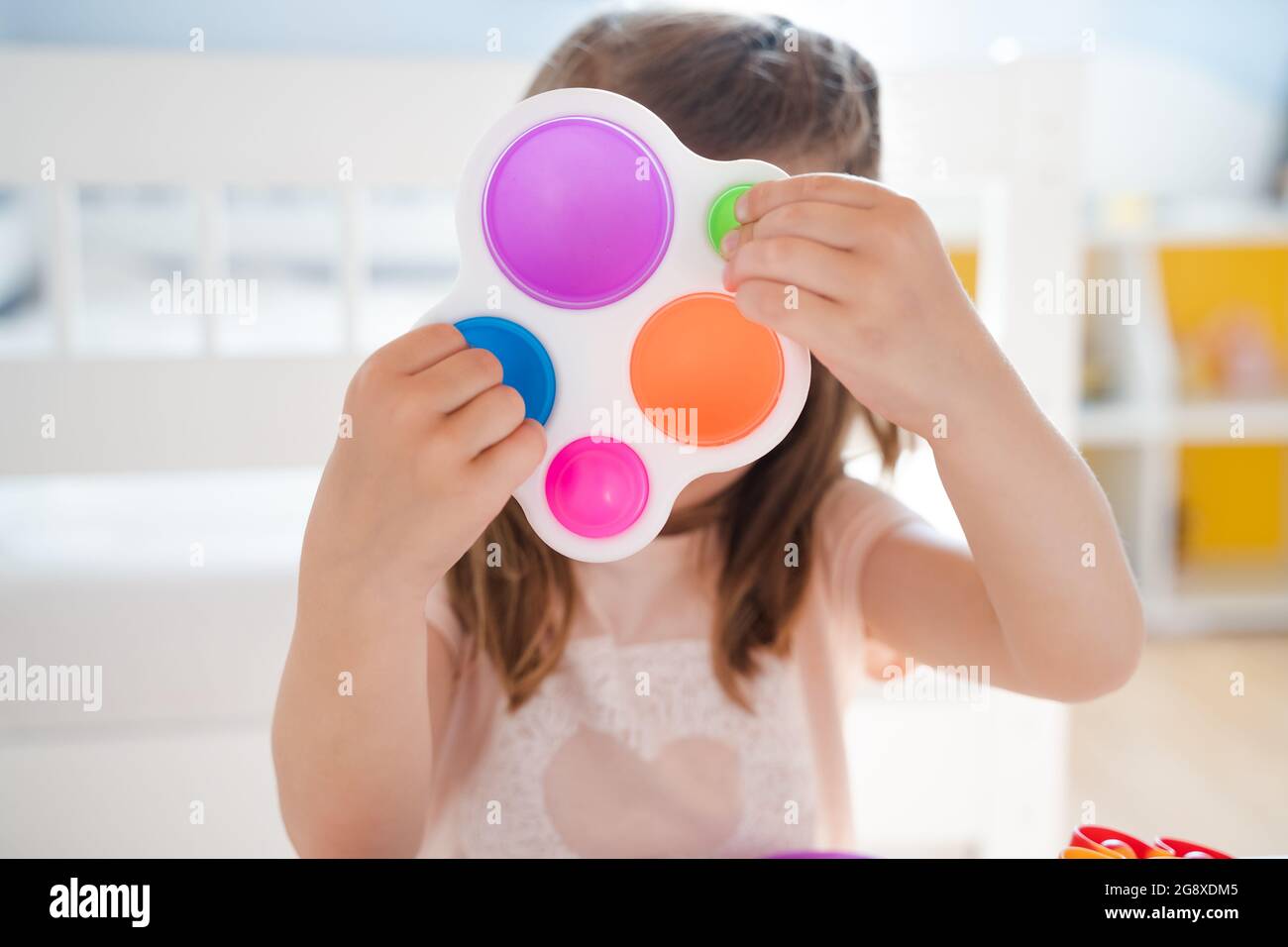 Little girl,kid,child plays with colorful pop it children's room ...